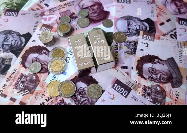 A silver bar, white metal against a backdrop of Mexican money, concept ...