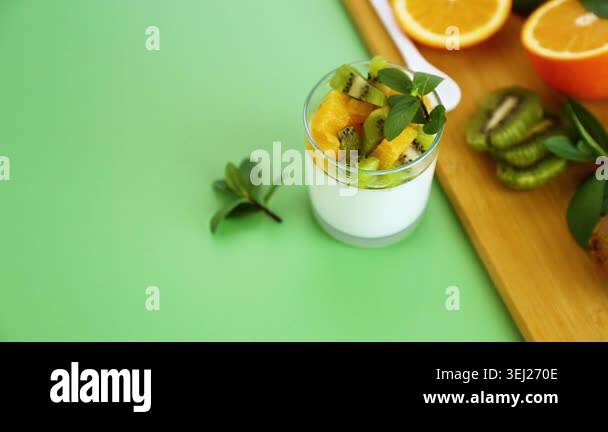 light yogurt snack with fresh kiwi orange and mint leaves Stock Video ...