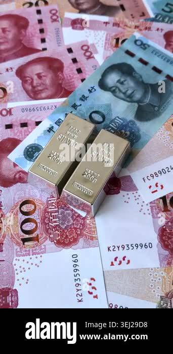 A silver bar, white metal against a backdrop of Chinese money, as a ...