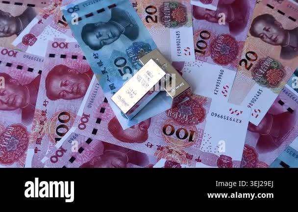 A silver bar, white metal against a backdrop of Chinese money, as a ...