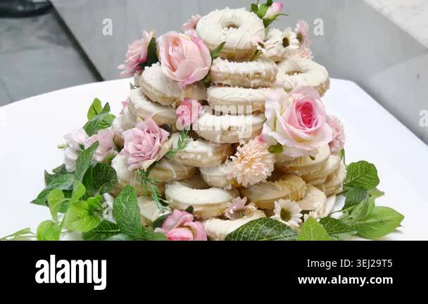 A beautiful white-glazed donut tower centerpiece, elegantly decorated ...