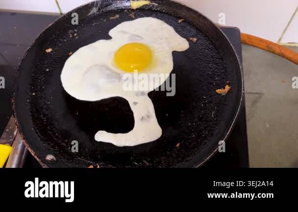 freshly cooked fried egg with bright yolk on traditional frying pan ...