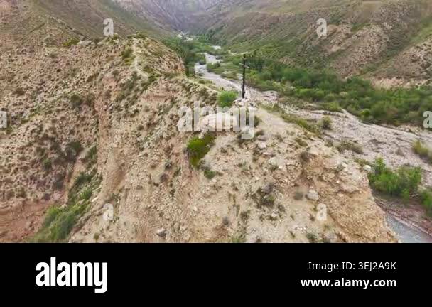 Drone aerial view circling an iron cross on top of a mountain with ...