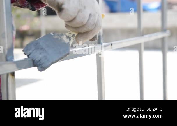 Close up of professional worker hand wearing dirty glove use brush to ...