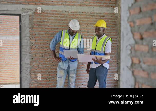 Professional black male builder team wearing safety helmet discuss ...