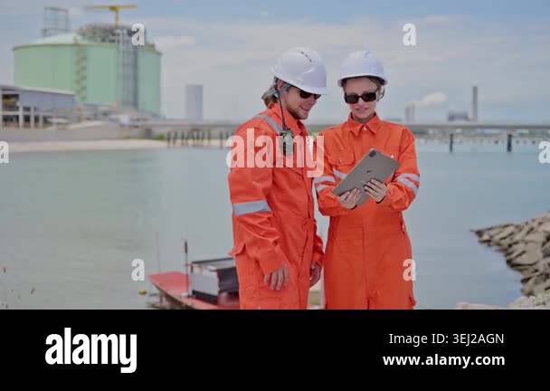 Couple energy worker wear safety orange uniform and helmet inspect ...