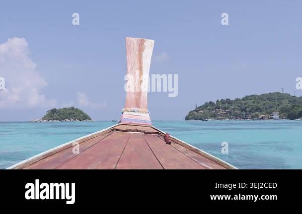 Small wooden boat cruising happily across calm blue ocean waves in a ...