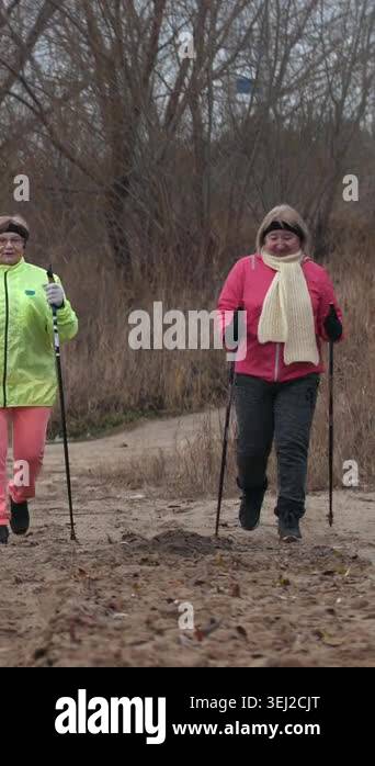 Two elderly woman in autumn park have modern healthy training - nordic ...