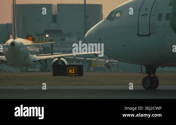 Planes are moving on the runway at the airport during dusk. Several ...