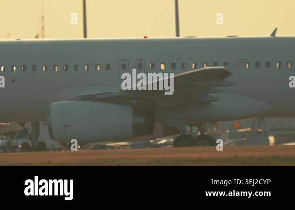An airplane is preparing for takeoff at the airport during sunset. The ...