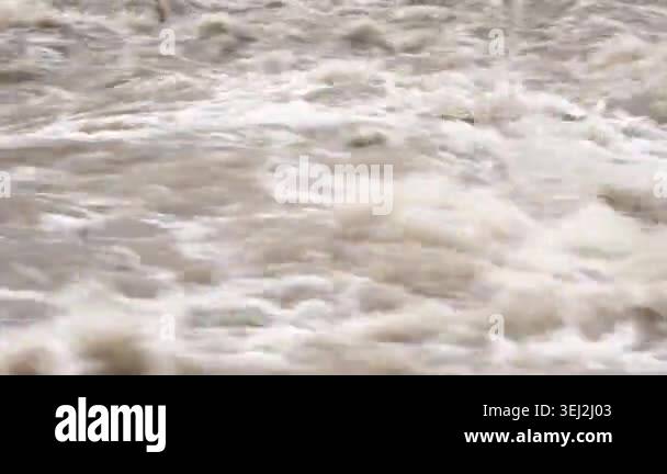 Rapid dirty river waves, drops of water flying in air, closeup detail ...