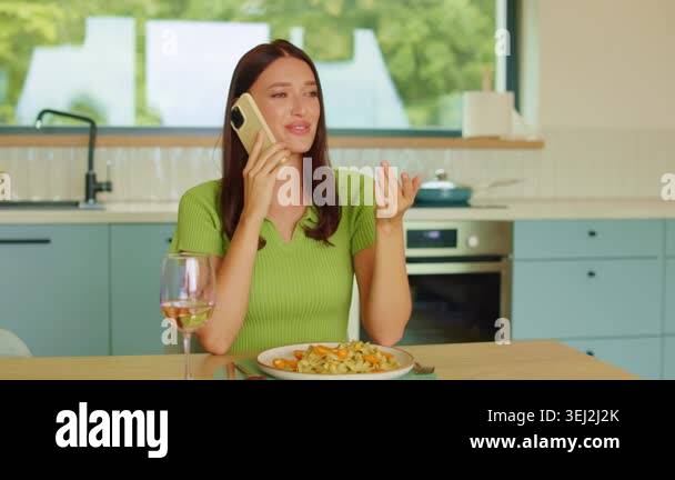 Medium shot of a cheerful young woman smiling and talking on her ...