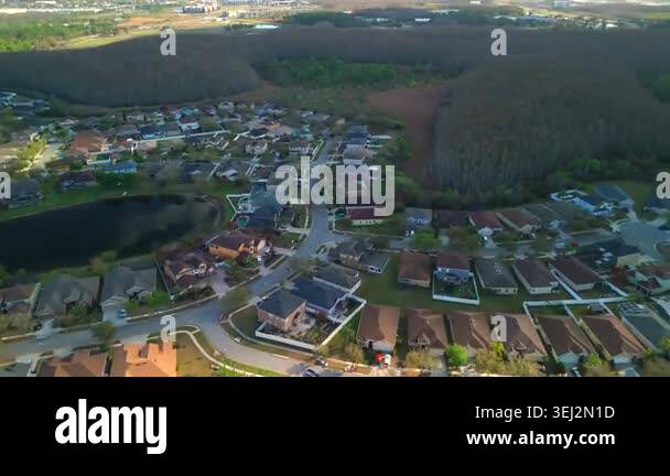Sideways drone view over suburban Orlando homes bordering forest ...