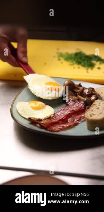 A professional chef prepares delicious fresh breakfast dishes in a ...