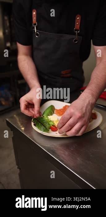 A professional chef prepares delicious fresh breakfast dishes in a ...