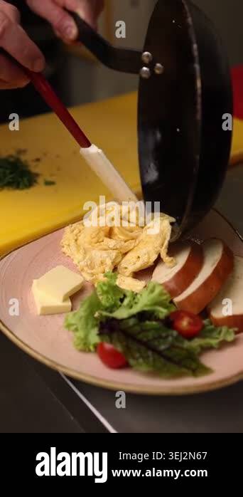 A professional chef prepares delicious fresh breakfast dishes in a ...