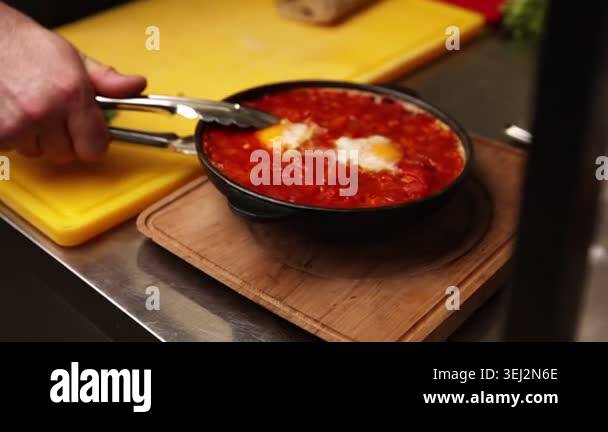 A professional chef prepares delicious fresh breakfast dishes in a ...