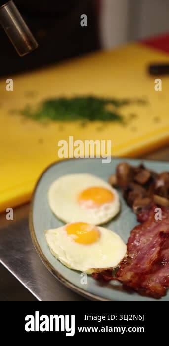 A professional chef prepares delicious fresh breakfast dishes in a ...