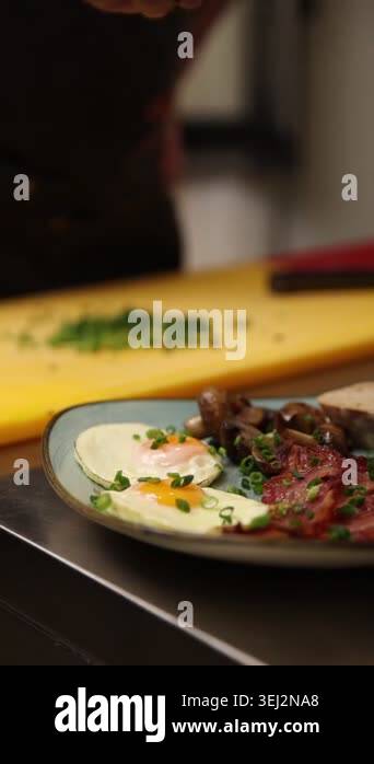 A professional chef prepares delicious fresh breakfast dishes in a ...