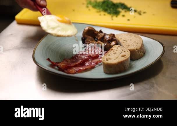A professional chef prepares delicious fresh breakfast dishes in a ...