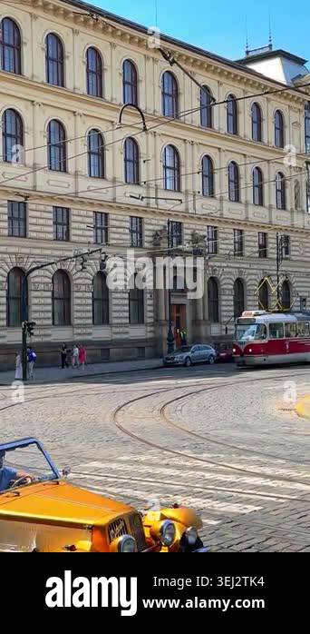 Prague, Czechia, May 5, 2026: A tram travels past a historic building ...