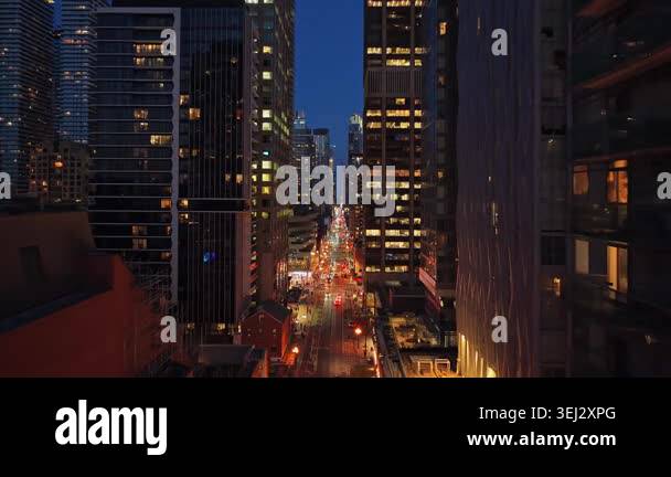 Aerial perspective of night city street surrounded by tall office ...