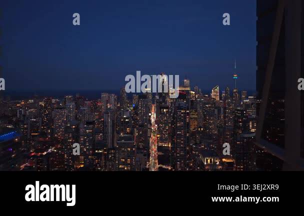 Aerial pull back shot between two skyscrapers in Torontos illuminated ...