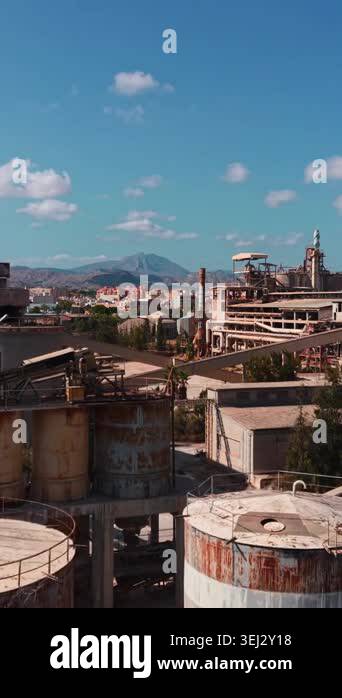 Aerial view of a desolate and abandoned factory with rusty tanks and ...