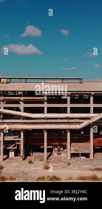 Aerial view of a deserted and decaying concrete factory against a clear ...