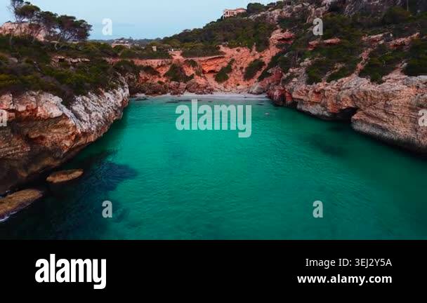 Turquoise waters embracing limestone cliffs at calo des moro, secluded ...