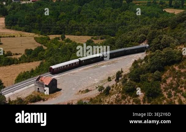 Aerial footage capturing an old fashioned passenger train moving along ...