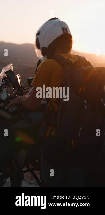 Back view of a male traveler taking off his helmet next to his ...