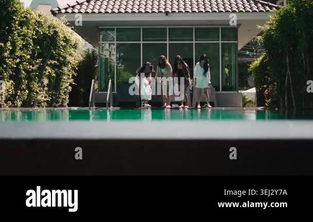 Group of four thai women sitting together on the edge of a swimming ...