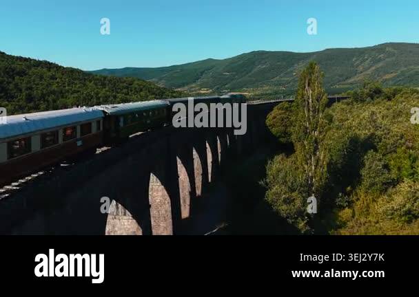 Majestic aerial perspective of a classic passenger train crossing an ...
