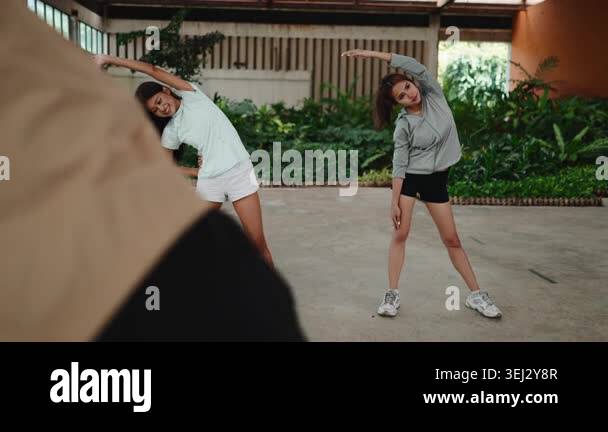 Young active women warming up together outdoors before their morning ...