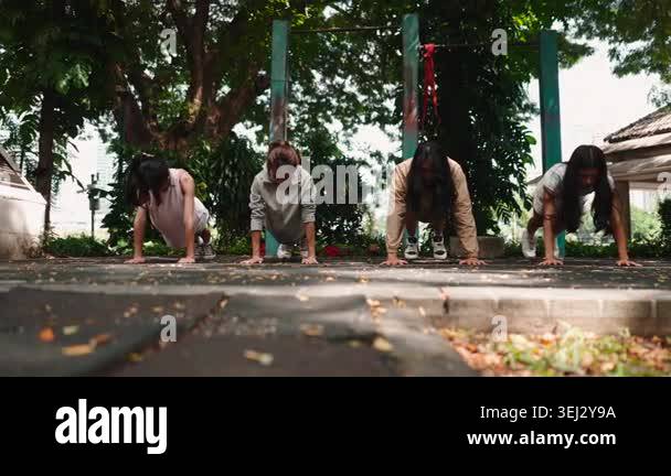 Four friends working out together, building strength with a push up ...