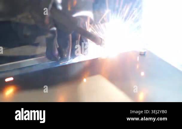Close up of welder using welding torch on stainless steel metal with ...