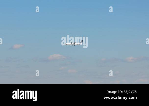 Turboprop passenger airplane with landing gear down flying over Toronto ...