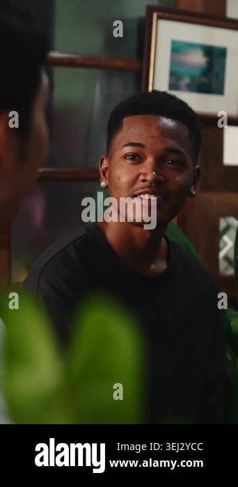 Charming young black man smiling and enjoying a lively conversation ...