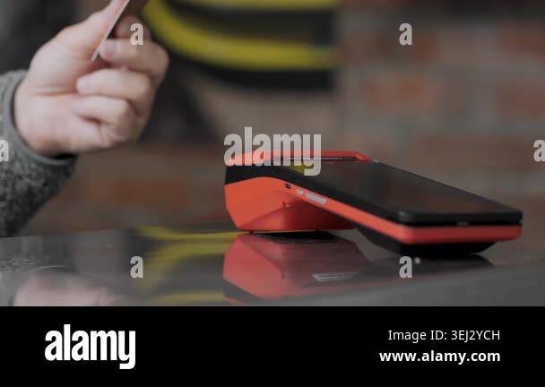 Close up of customer paying with bank card using payment terminal at ...
