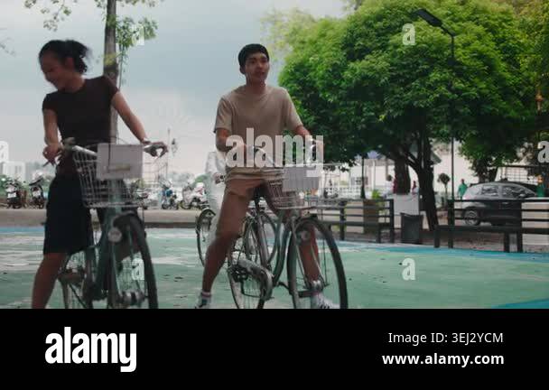 Group of smiling young friends enjoying a bike ride together in an ...