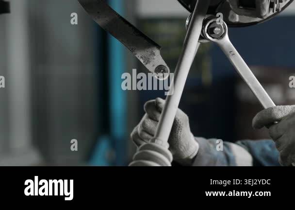 Detailed close up of mechanic hands repairing vehicle suspension system ...