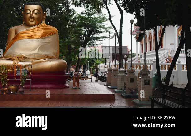 Large golden buddha statue sitting in meditation pose at a traditional ...