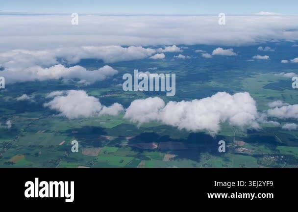 Aerial view from airplane of green meadows. White cumulus clouds in ...