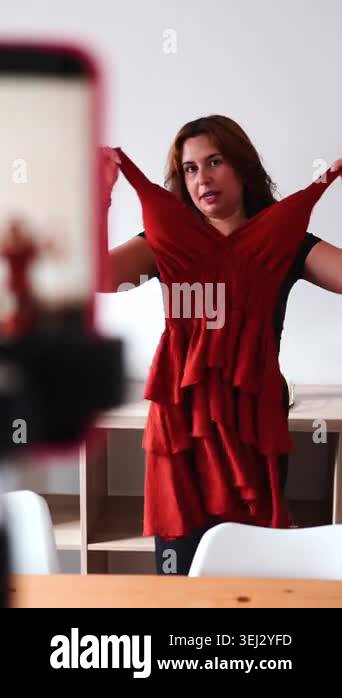 Female content creator recording a fashion haul, showing a stylish red ...