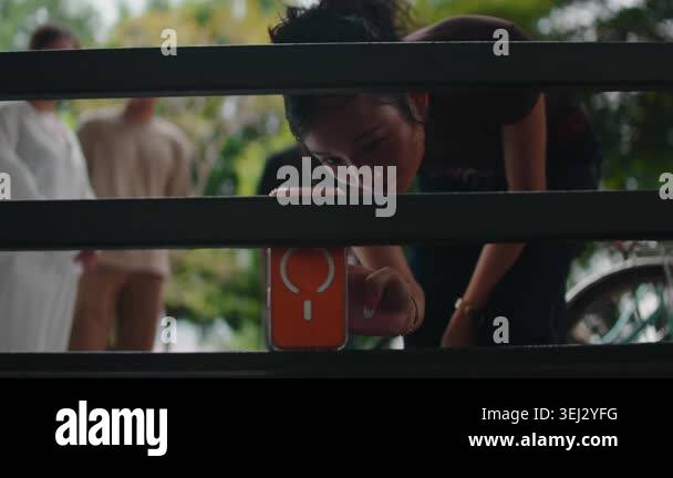 Diverse group of young friends unlocking and renting a public bicycle ...
