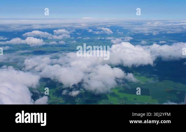 Aerial view from airplane of green meadows. White cumulus clouds in ...