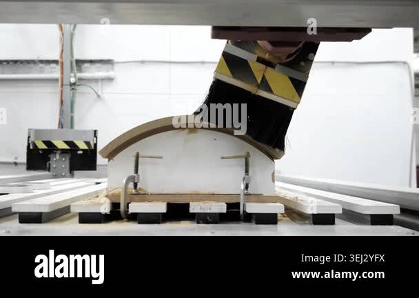 CNC router machine milling a curved wooden part in furniture production ...