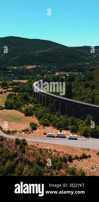 Scenic aerial view of motorhomes parked near a historic arched railway ...