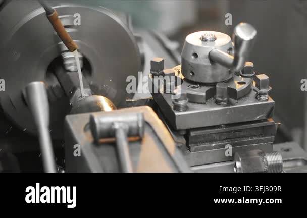 Close up of industrial lathe machine machining metal part with coolant ...